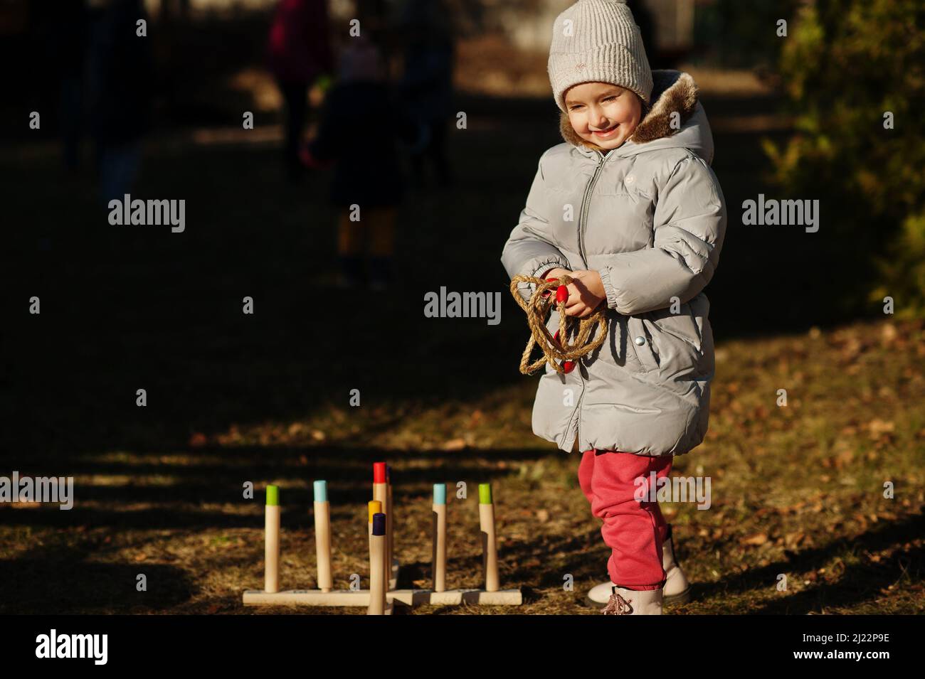 Baby girl playing a game throwing ring toss outdoor Stock Photo - Alamy