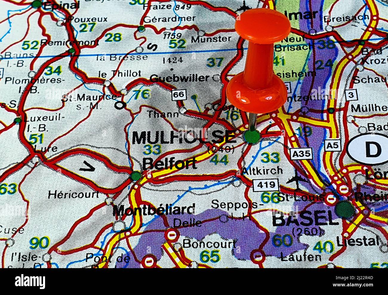 A closeup of a red pin pointing the location on the map of Mulhouse ...