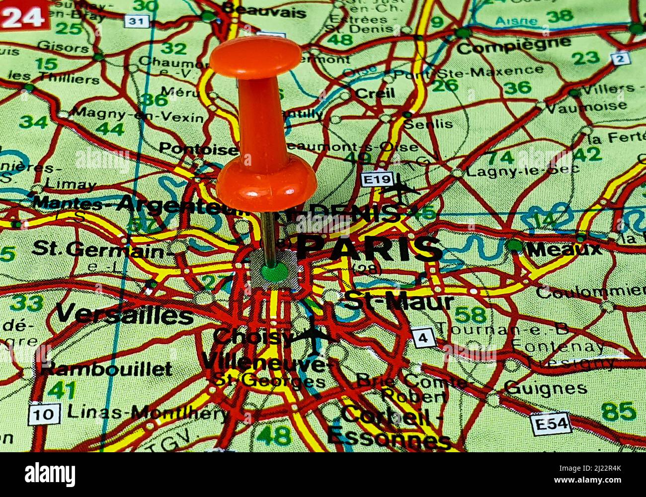 A closeup of a red pin pointing the location on the map of Paris city ...