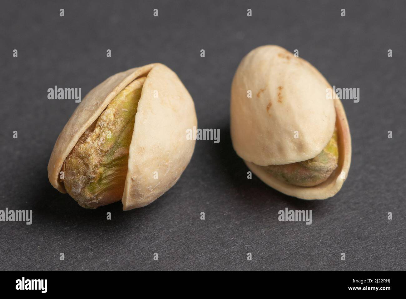 Peeled and unpeeled pistachios on dark background Stock Photo - Alamy