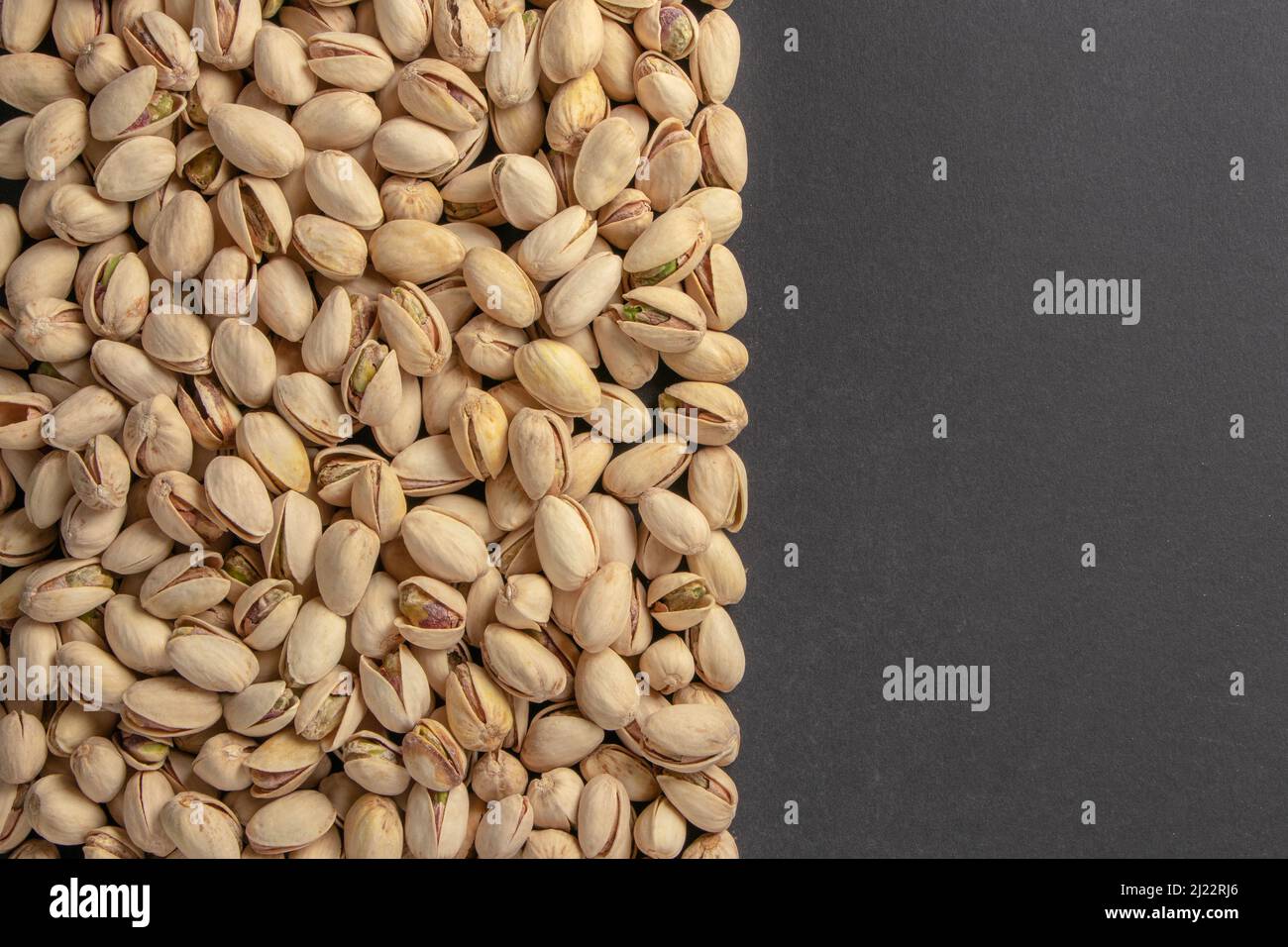 Roasted and salted pistachios in shell on dark background Stock Photo ...