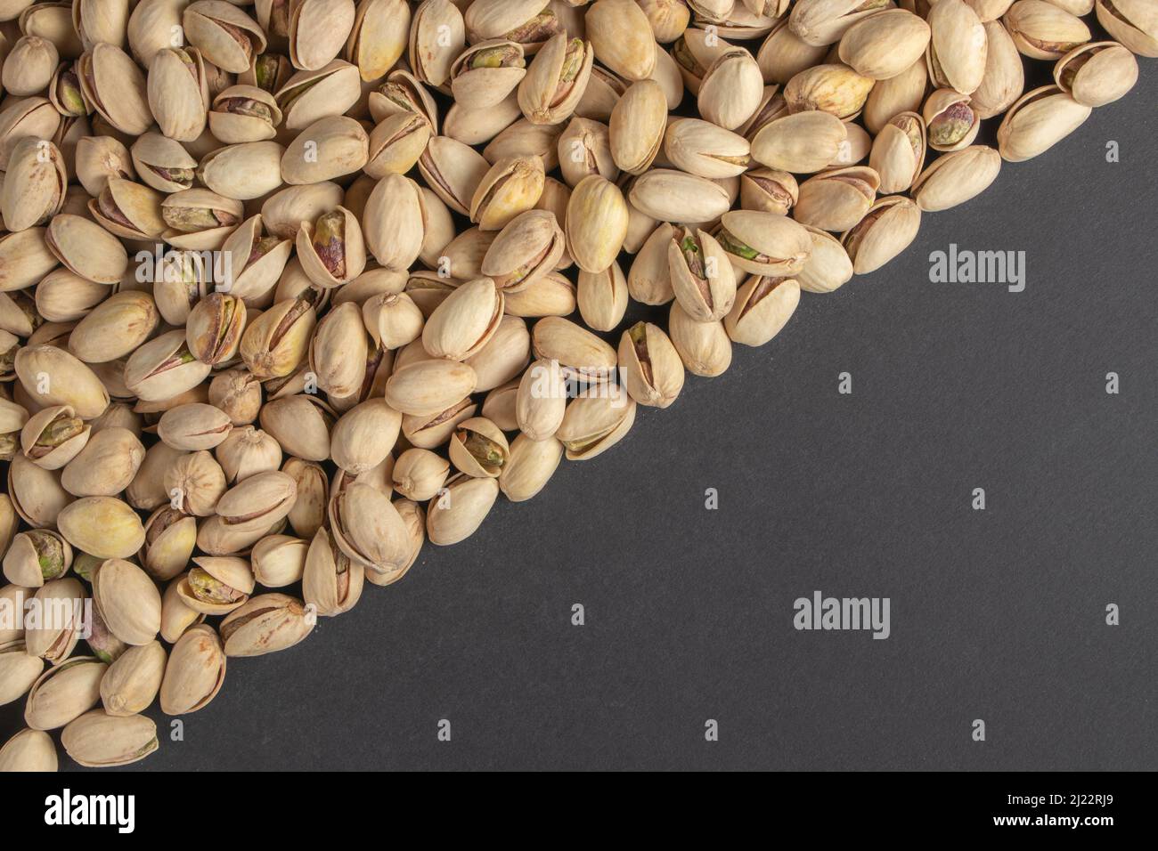 Roasted and salted pistachios in shell on dark background Stock Photo ...