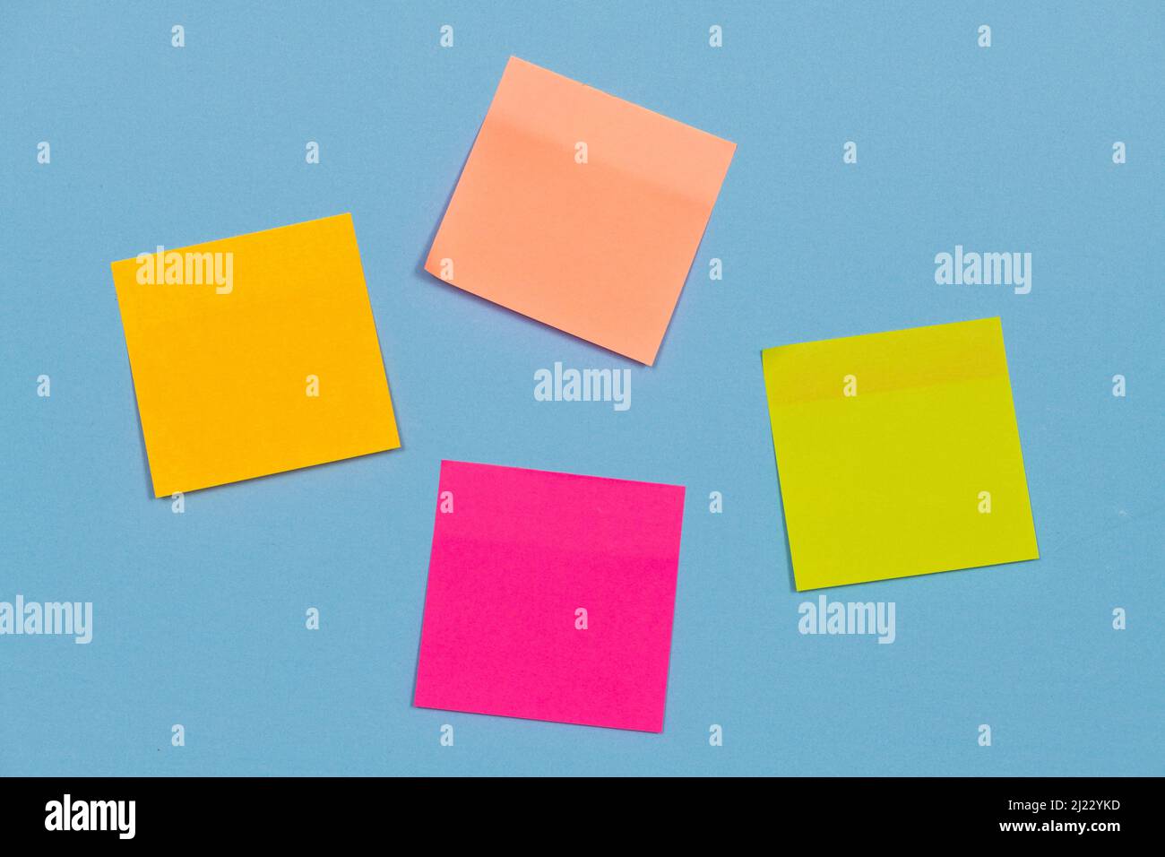 Coloured adhesive paper notes stuck to a blue background Stock Photo ...