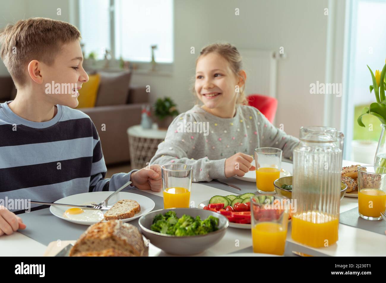 Teen brother and sister eating healthy breakfast at home before school ...