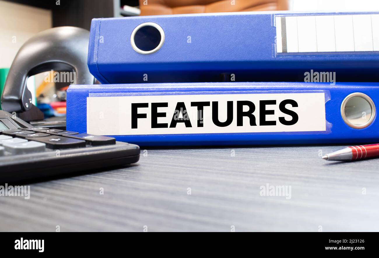 FEATURE written in a notebook on white background with office tools ...