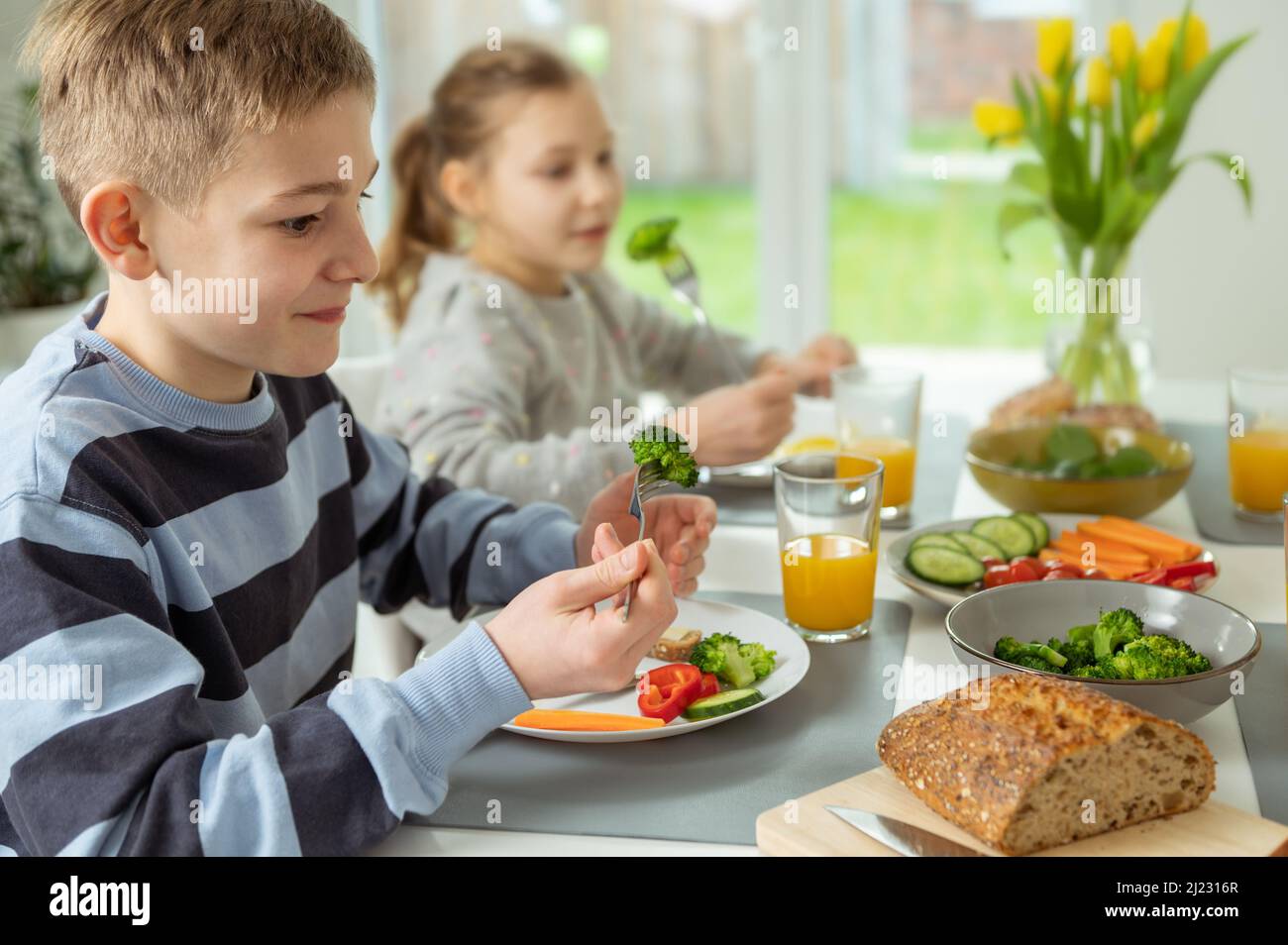 Teen brother and sister eating healthy breakfast at home before school ...
