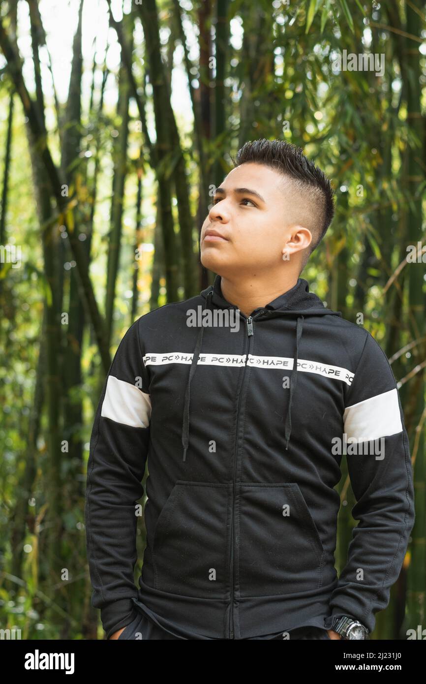 young latin looking up at the beautiful nature, in the middle of a ...