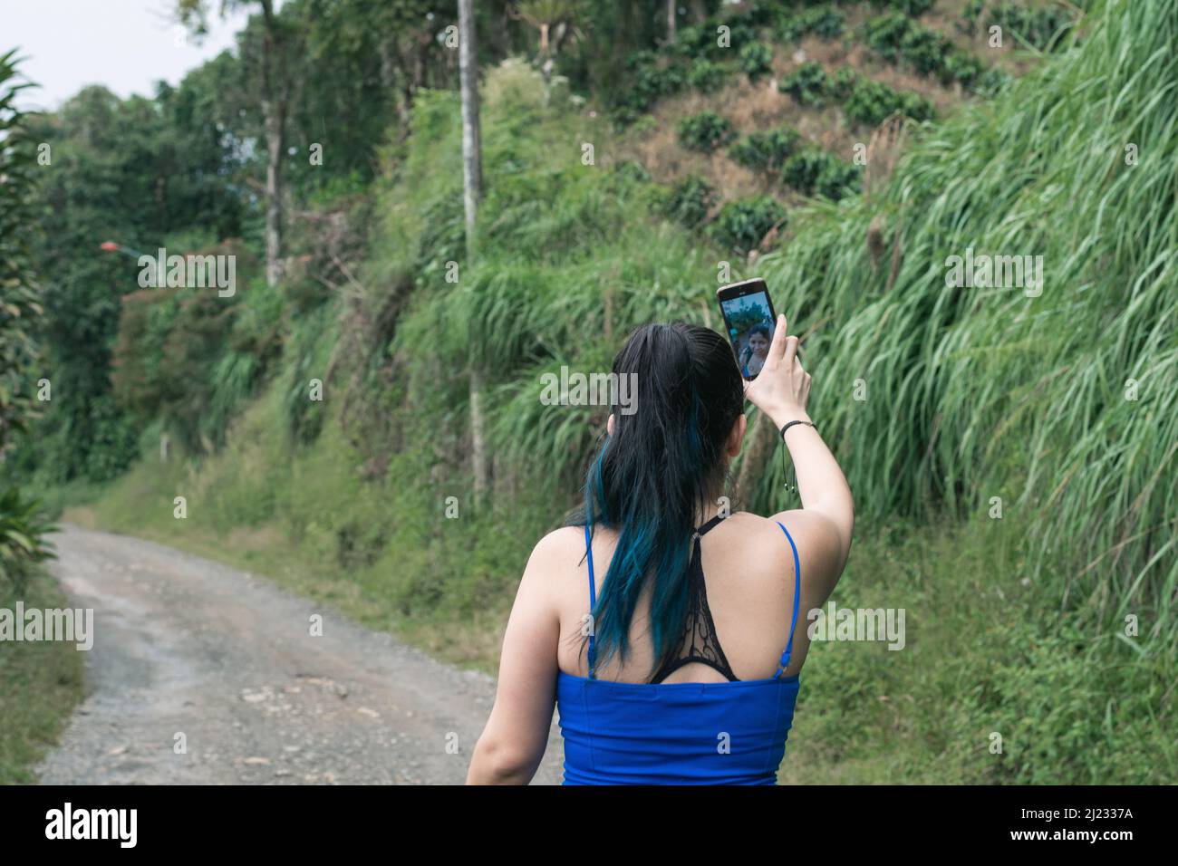 young latina hiking on an ecological trail in Colombia while ...