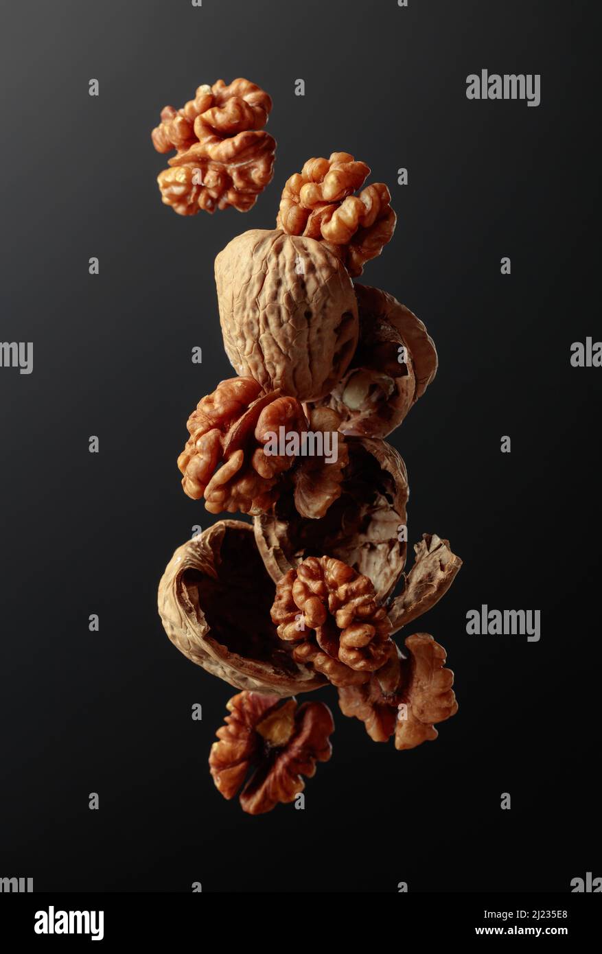 Food levitation. Walnuts on a black background Stock Photo - Alamy