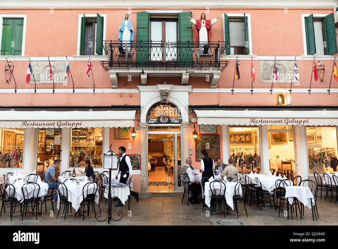 Italy, Venice, Burano, restaurant with outdoor tables with a few people ...