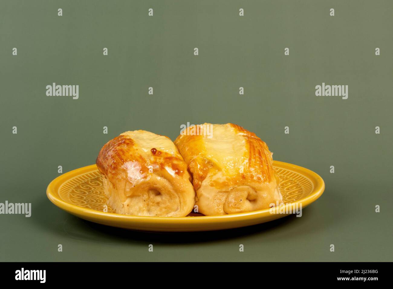 Brazilian sweet bread from bakery on yellow plate and green background ...