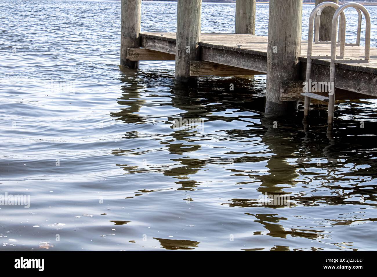 Strong reflection from the water with a old pier extending out over it ...