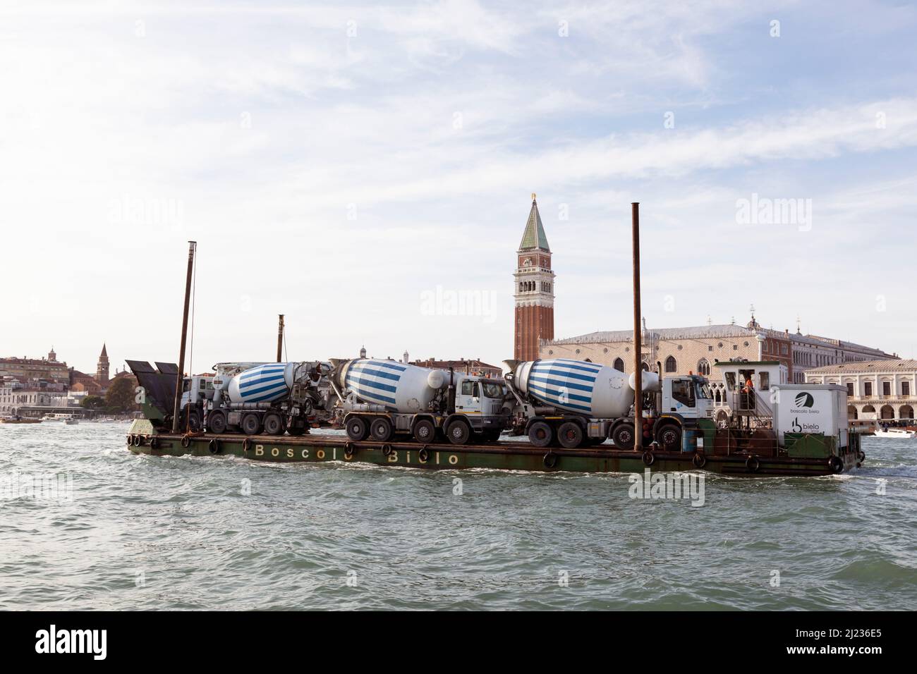 Italy, Venice, cement trucks being transported by barge on the Grand ...
