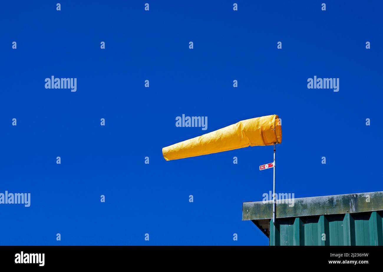 Yellow windsock and blue sky Stock Photo - Alamy