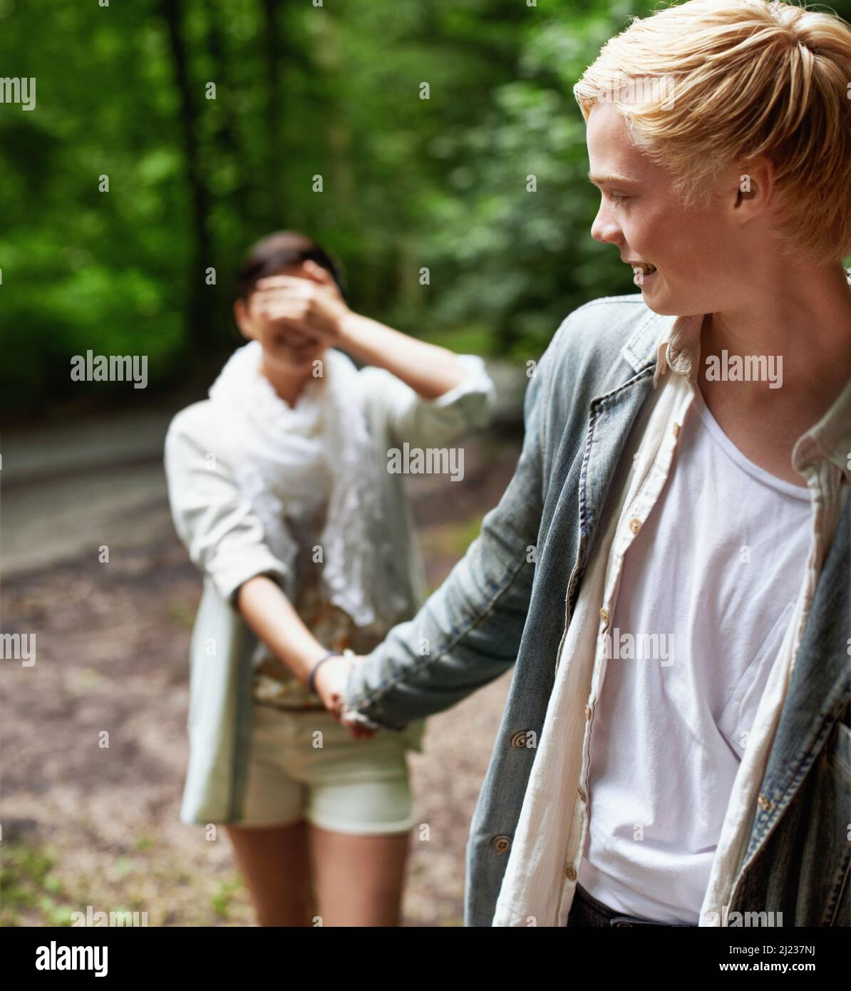 Totally trusting in one another. A girl covering her eyes with her hand ...