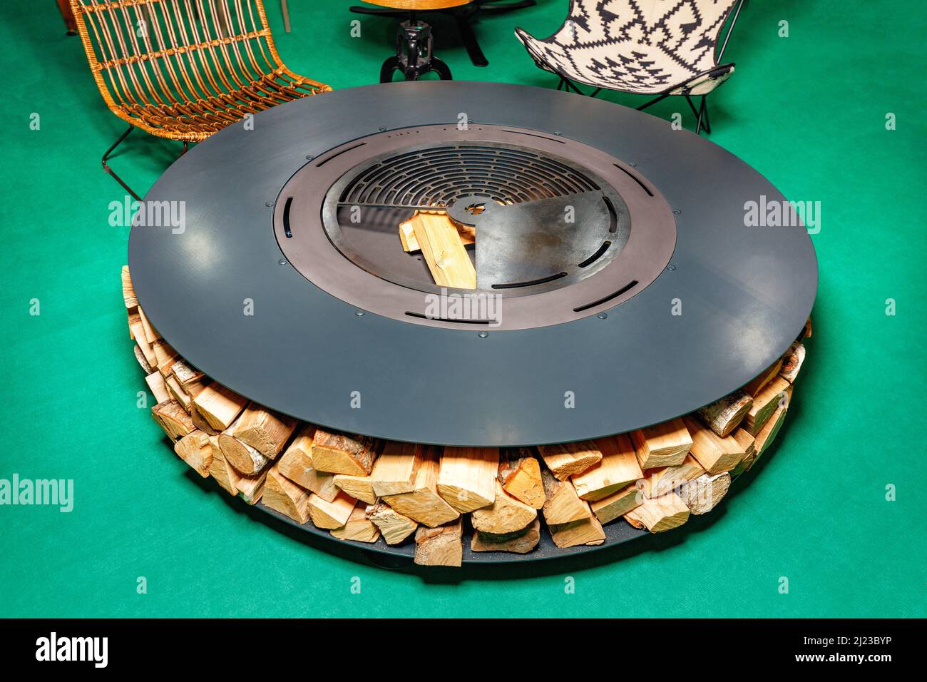 Garden round BBQ hearth, with dining area, central grill and firewood ...