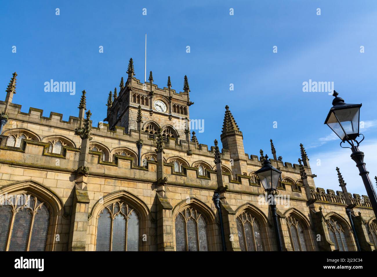 All Saints' Church, also known as Wigan Parish Church, with blue sky's ...