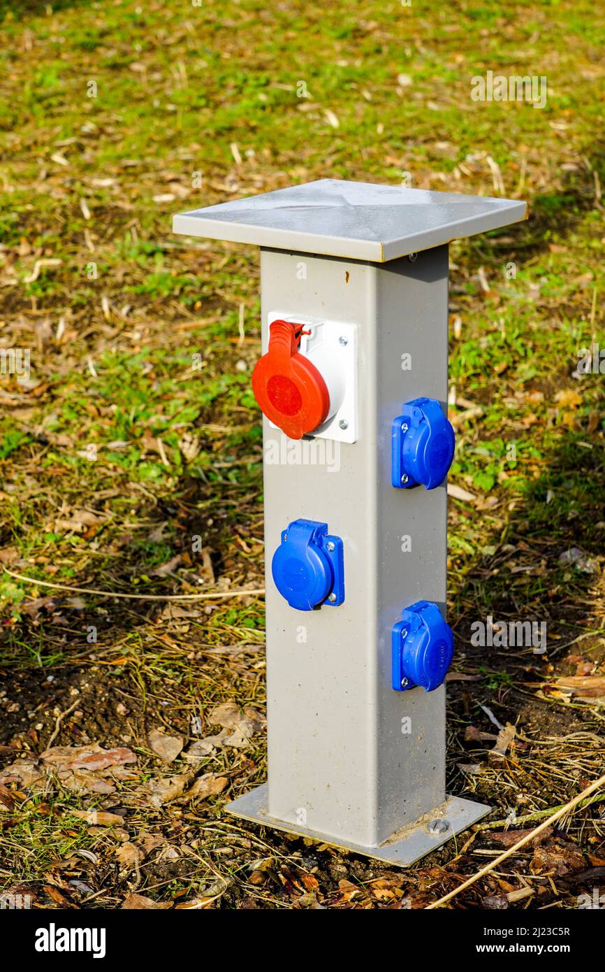 new modern multiple electrical power outlets on a low metal pole in a ...