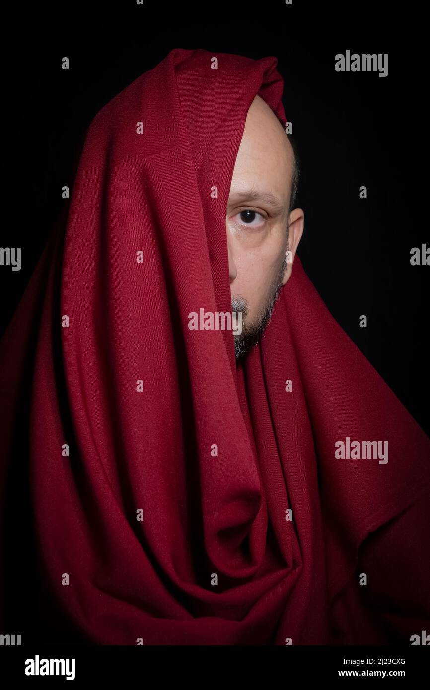 Man covered with red cloth against a black background. Salvador, Bahia ...