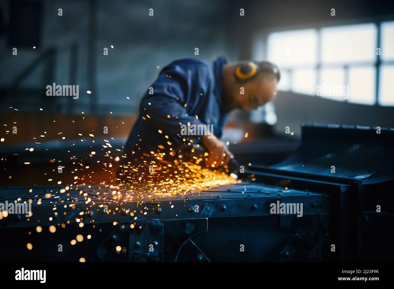 Industrial worker cutting and welding metal with special equipment at ...