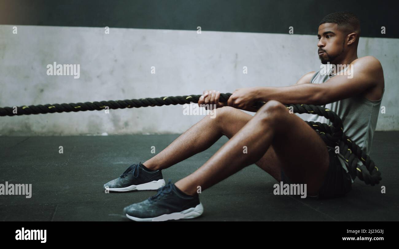 Inching closer and closer to great results. Shot of a young man pulling ...