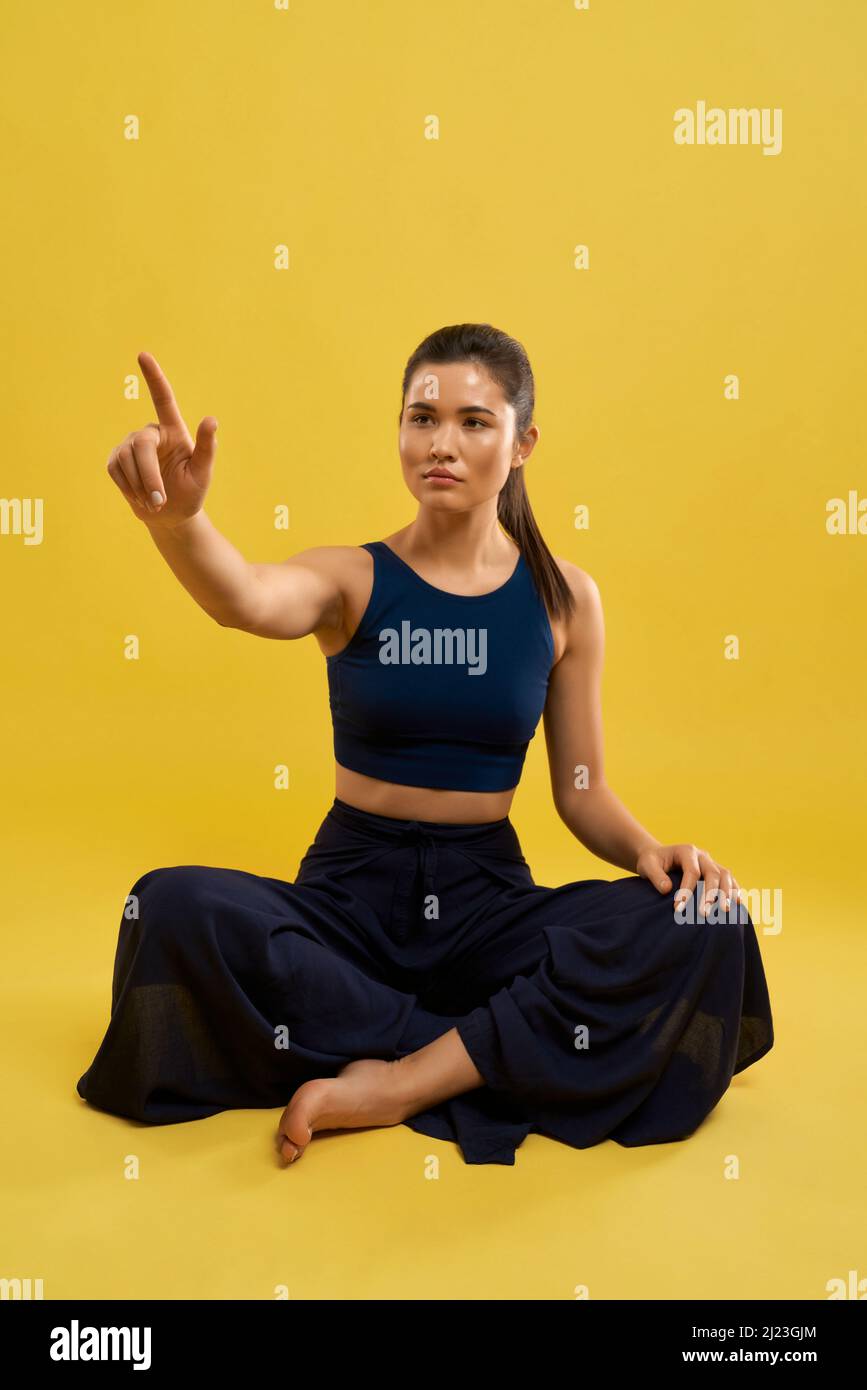 Crop of sporty girl with pony tail practicing yoga at studio. Slim ...