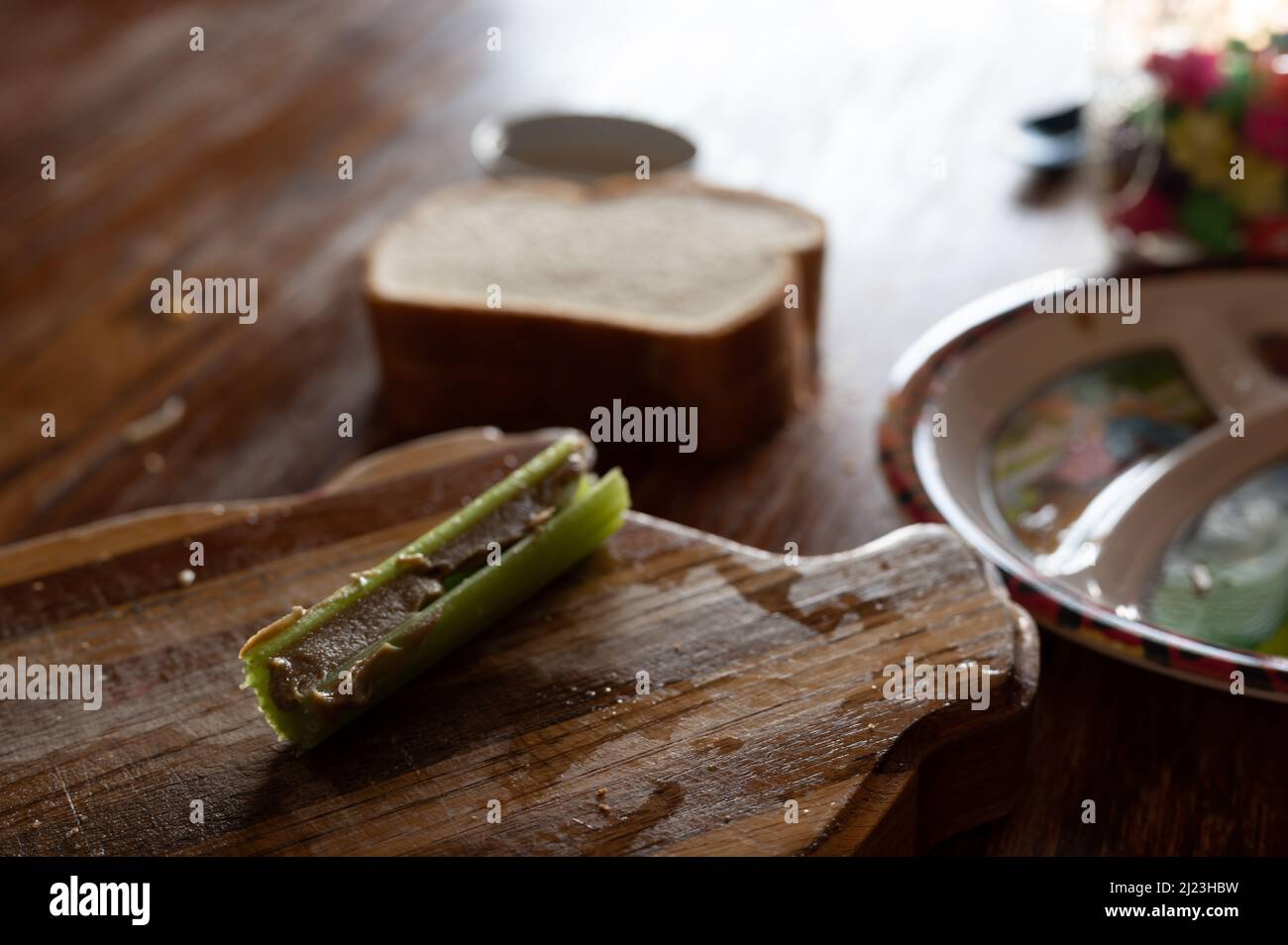 selective focus on celery stick filled with sun butter on a cutting ...