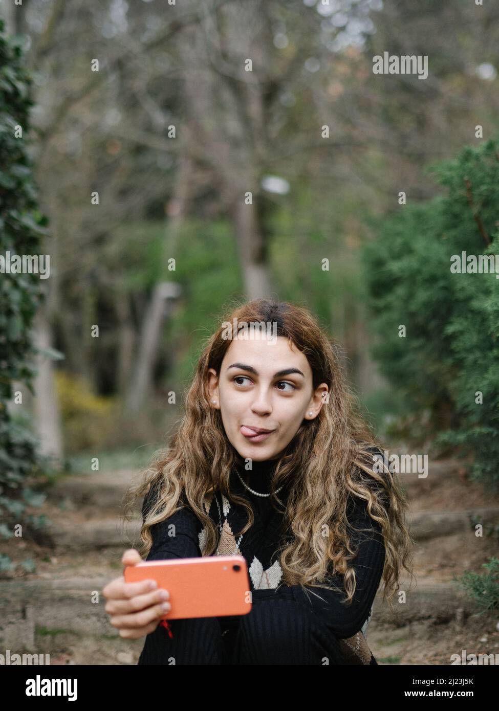 A Closeup Portrait Of A Teenage Girl Tanking Selfies On Her Phone With