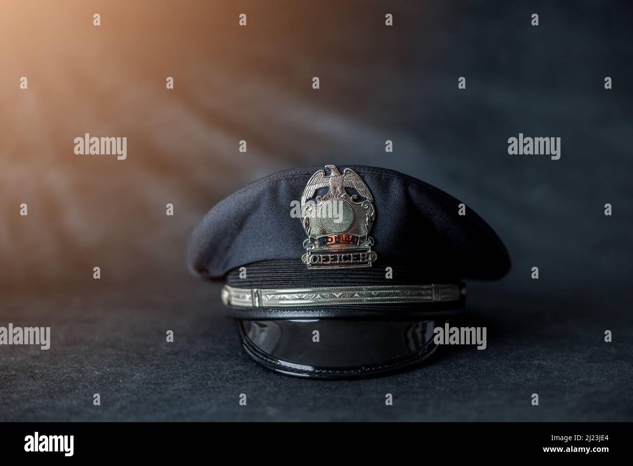 A navy blue police hat cap in front of a navy blue background with hazy ...