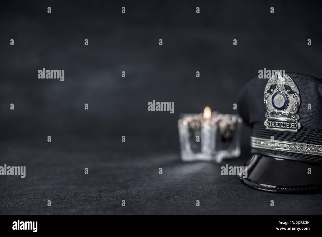 A navy blue police hat cap in front of a navy blue background with a ...