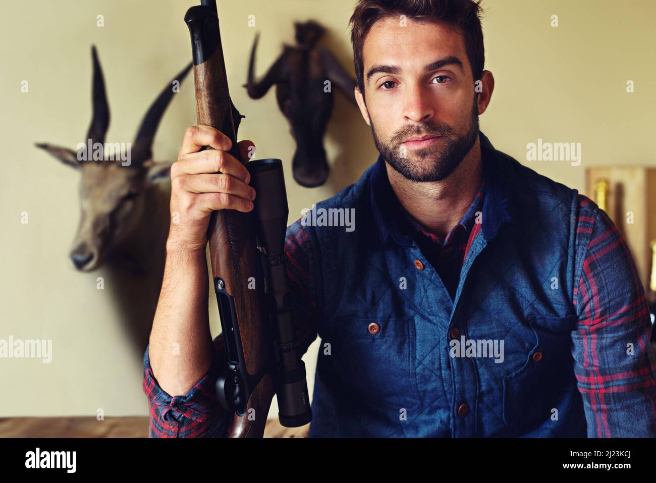 Hes a great shot. Portrait of a hunter sitting in front of his trophies ...