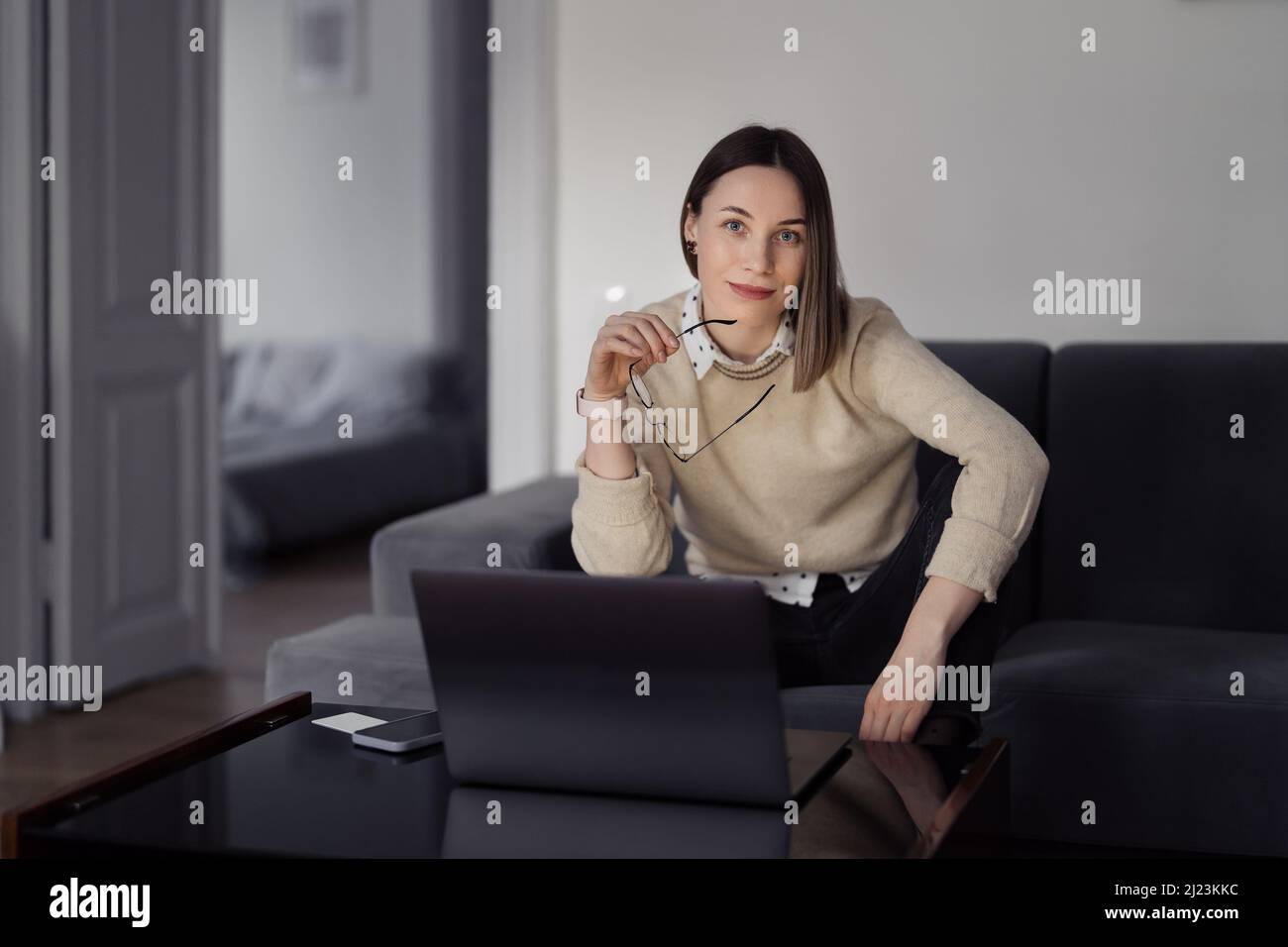 Caucasian Woman using laptop while sitting on the sofa at home in the ...