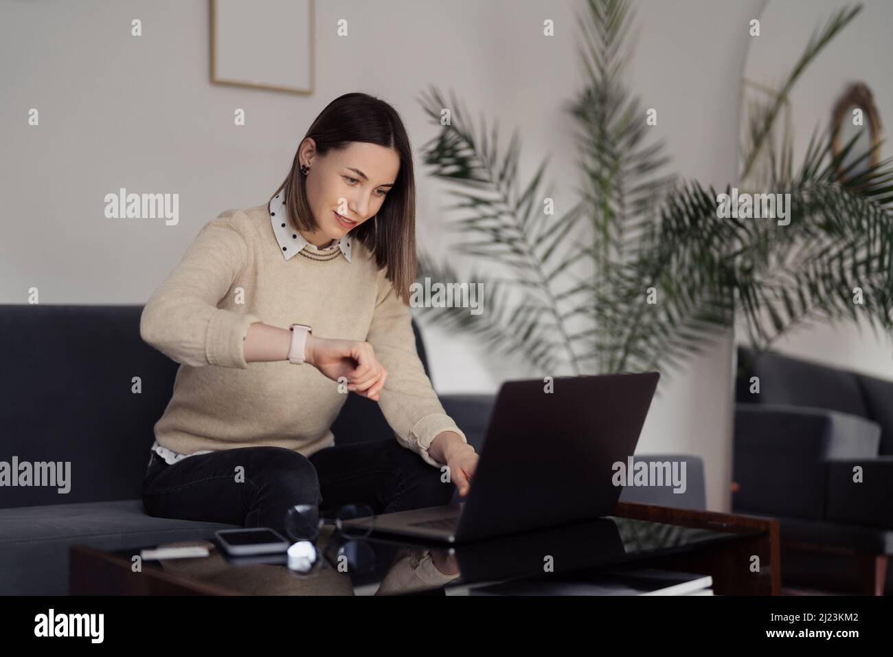 Caucasian Woman using laptop while sitting on the sofa at home in the ...
