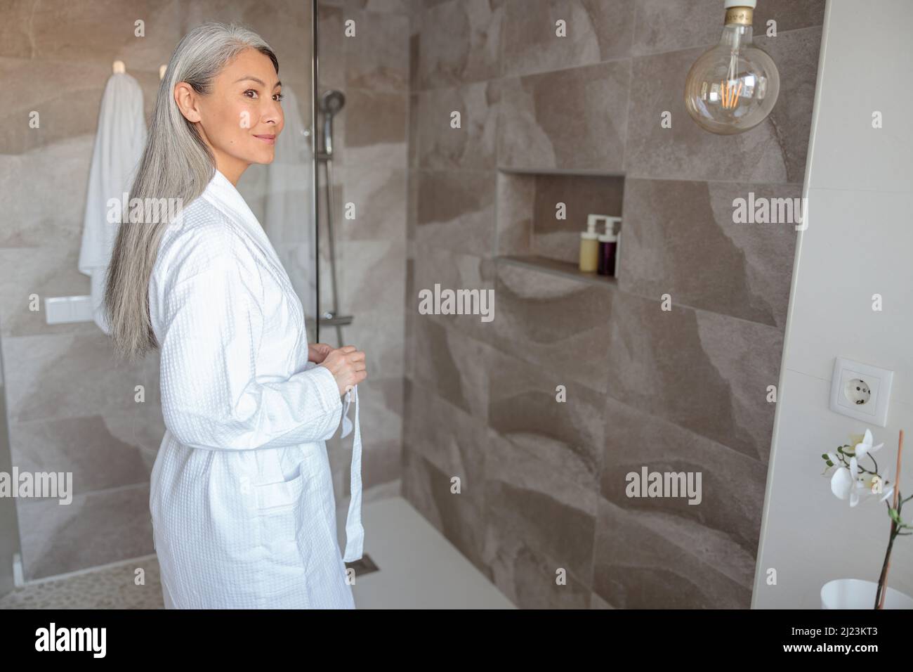 Charming woman in bathrobe preparing to take shower Stock Photo - Alamy