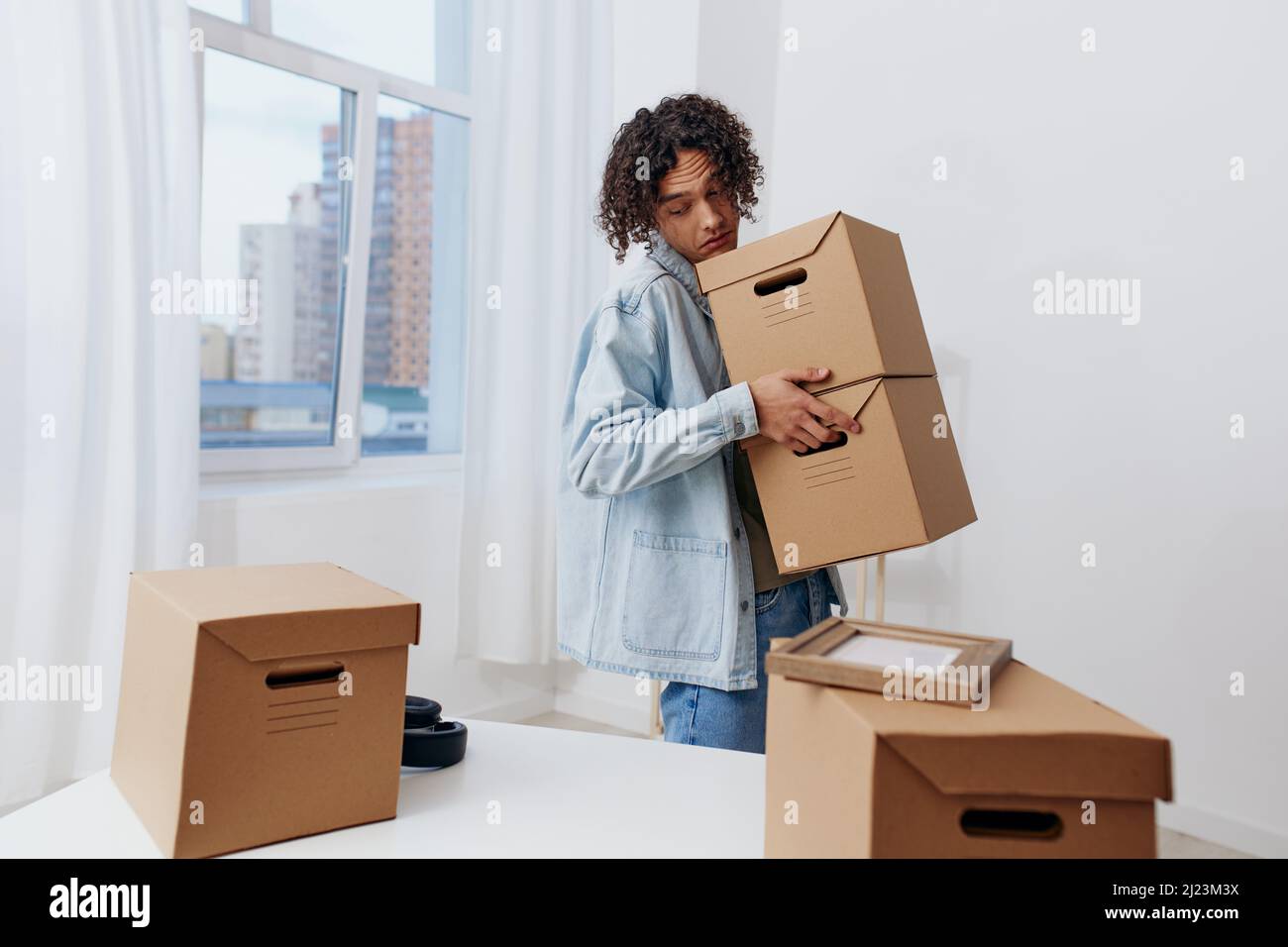 portrait of a man unpacking things from boxes in the room Lifestyle ...