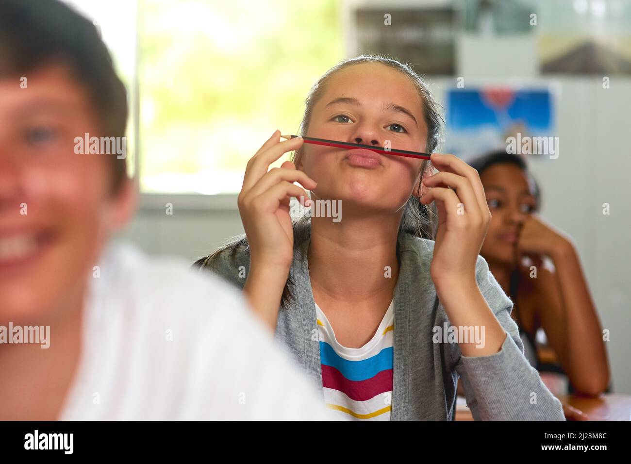 Classroom shenanigans. Shot of a young schoolgirl pulling a funny face ...