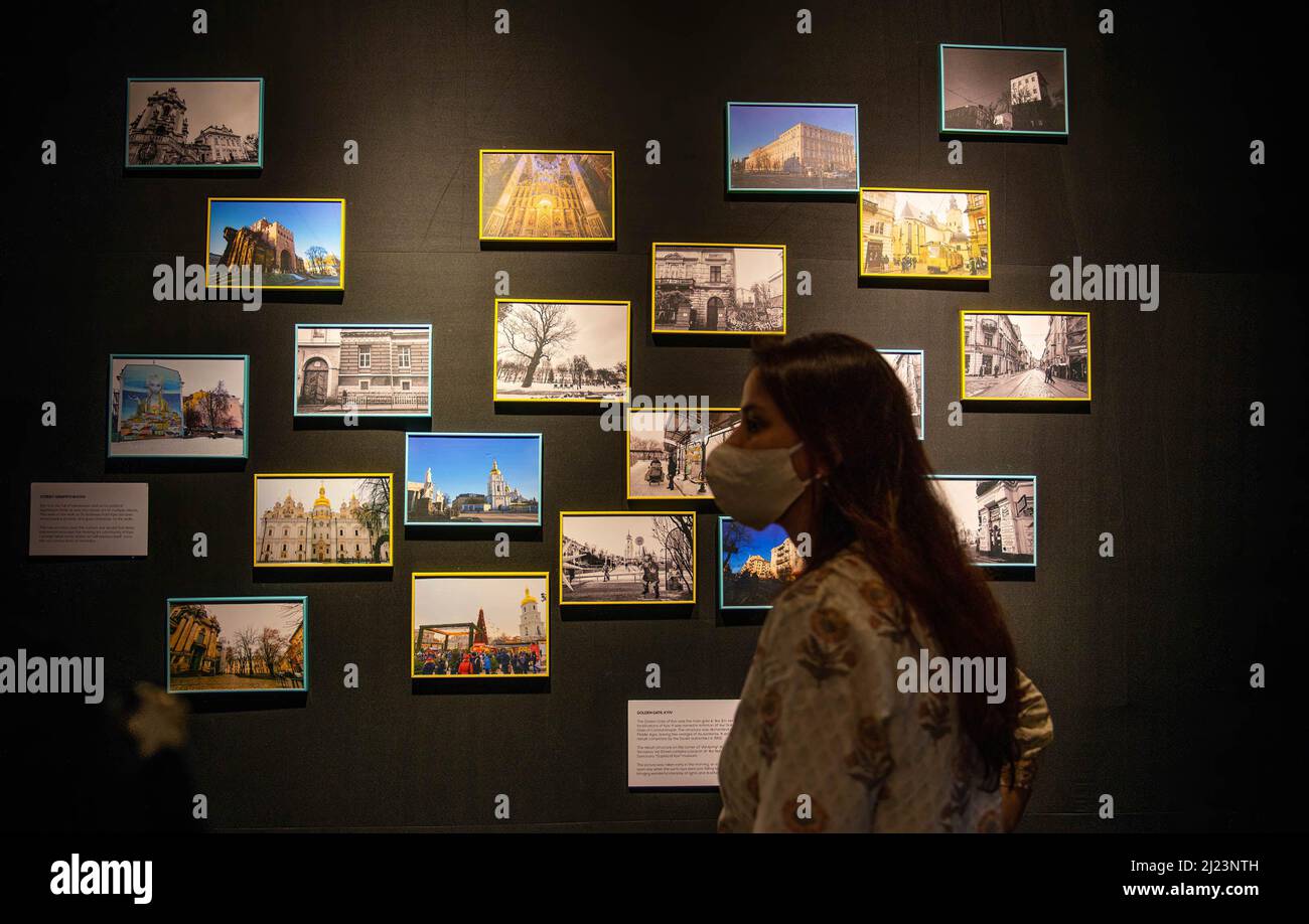 A visitor seen next to a wall of framed photos during a preview of the ...