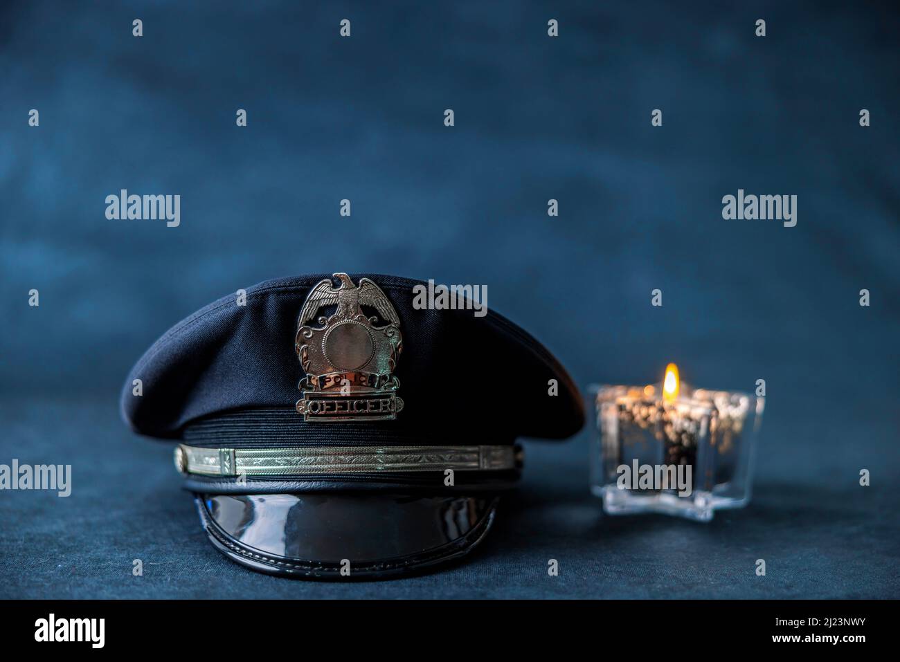 A navy blue police hat cap in front of a navy blue background with a ...