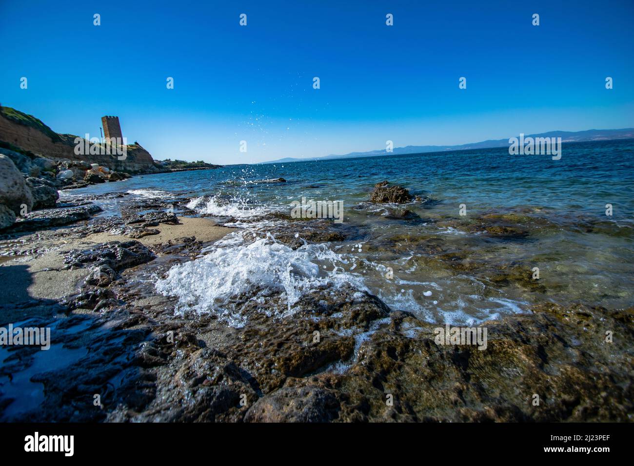 The ocean waves collide with the stone making foam Stock Photo - Alamy