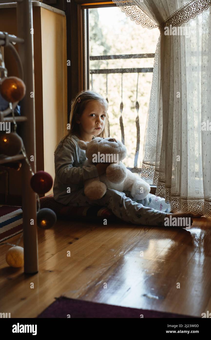 Child sitting on the floor and playing ant home. Dreamy sunny mood ...