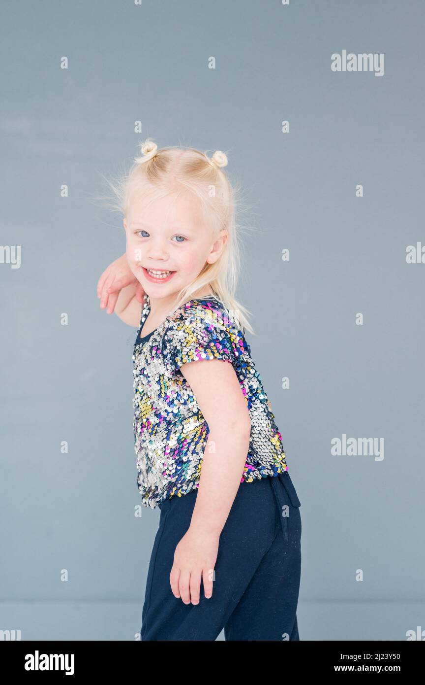 Preschool aged girl looking over shoulder and laughing Stock Photo - Alamy