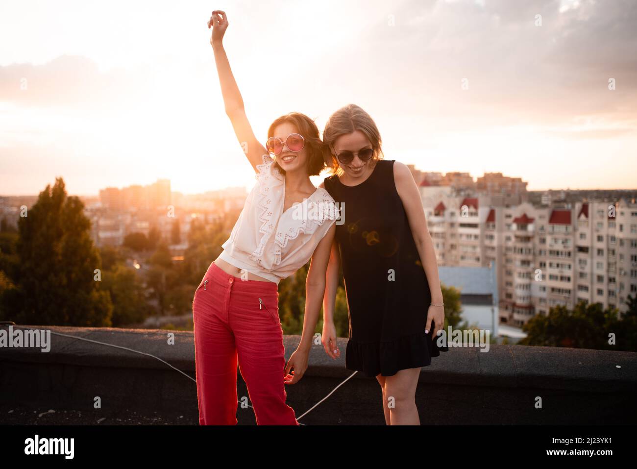 two friends on roof on sunset Stock Photo - Alamy