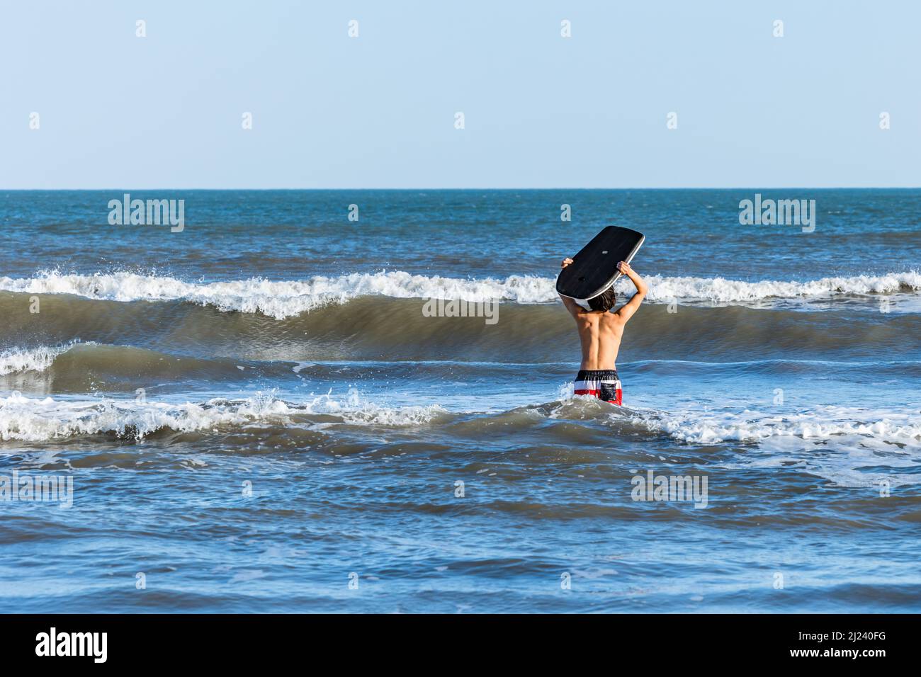 Teenage Boy With Black Bodyboard in the Ocean Stock Photo - Alamy