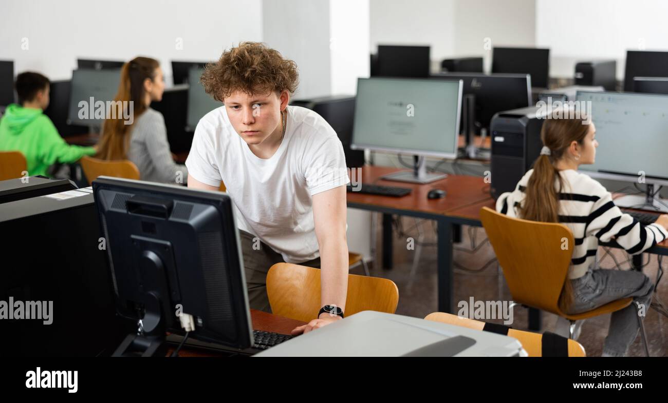 Portrait of guy working at computer in computer class at school Stock ...