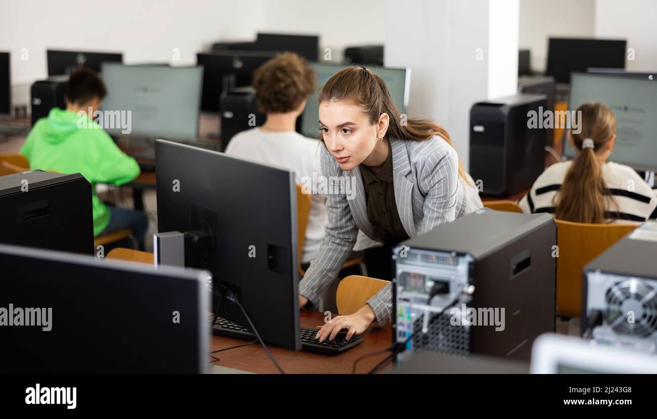 Teacher using personal computer during lesson in school Stock Photo - Alamy