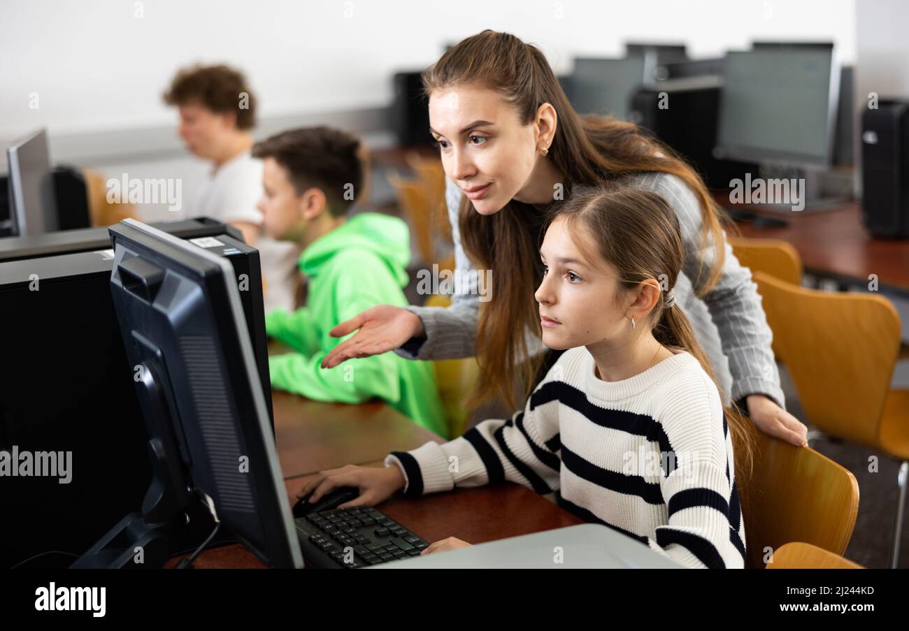 Teacher together with students conduct lesson on computer education ...