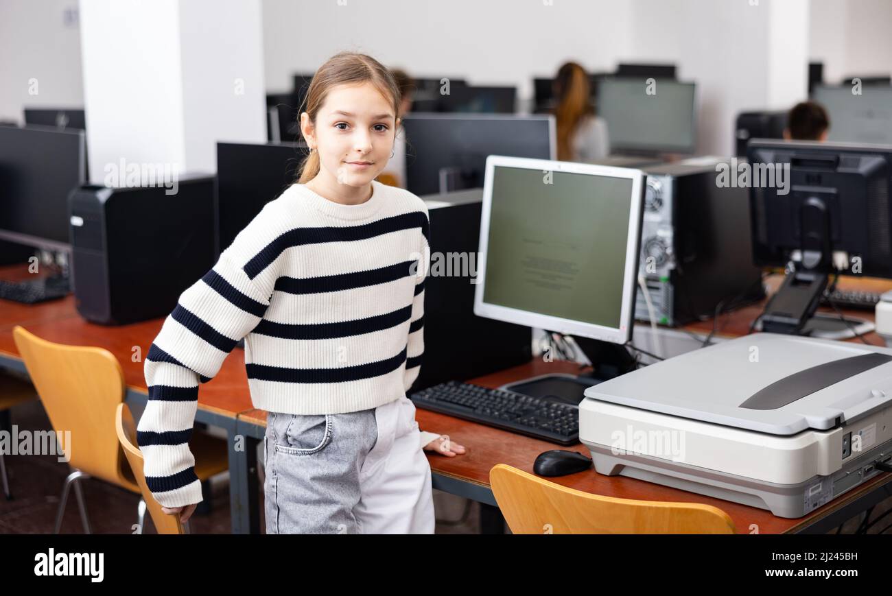 Interested teenage girl student standing in information technology ...