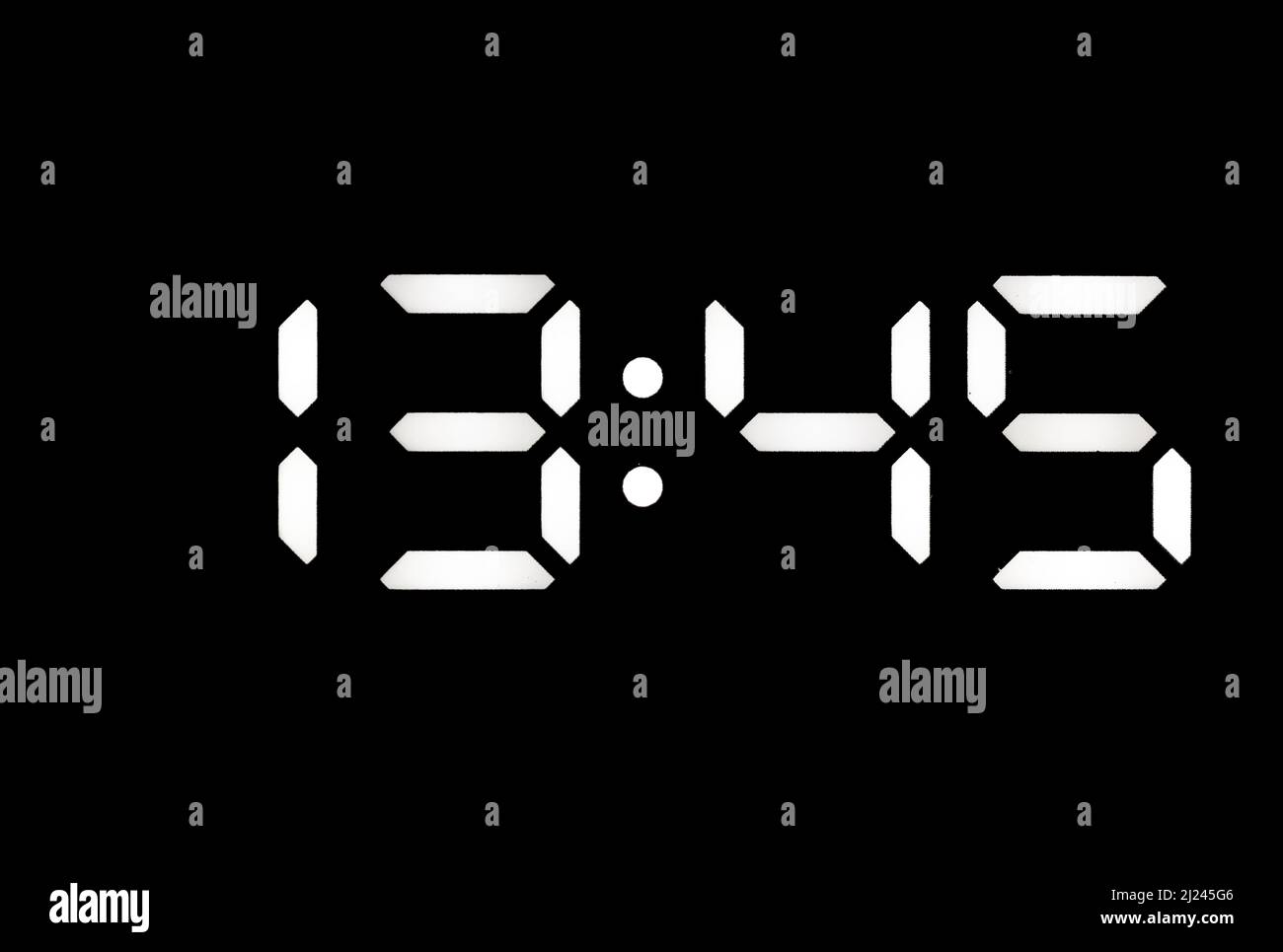 Real white led digital clock on a black background showing time 13:45 ...