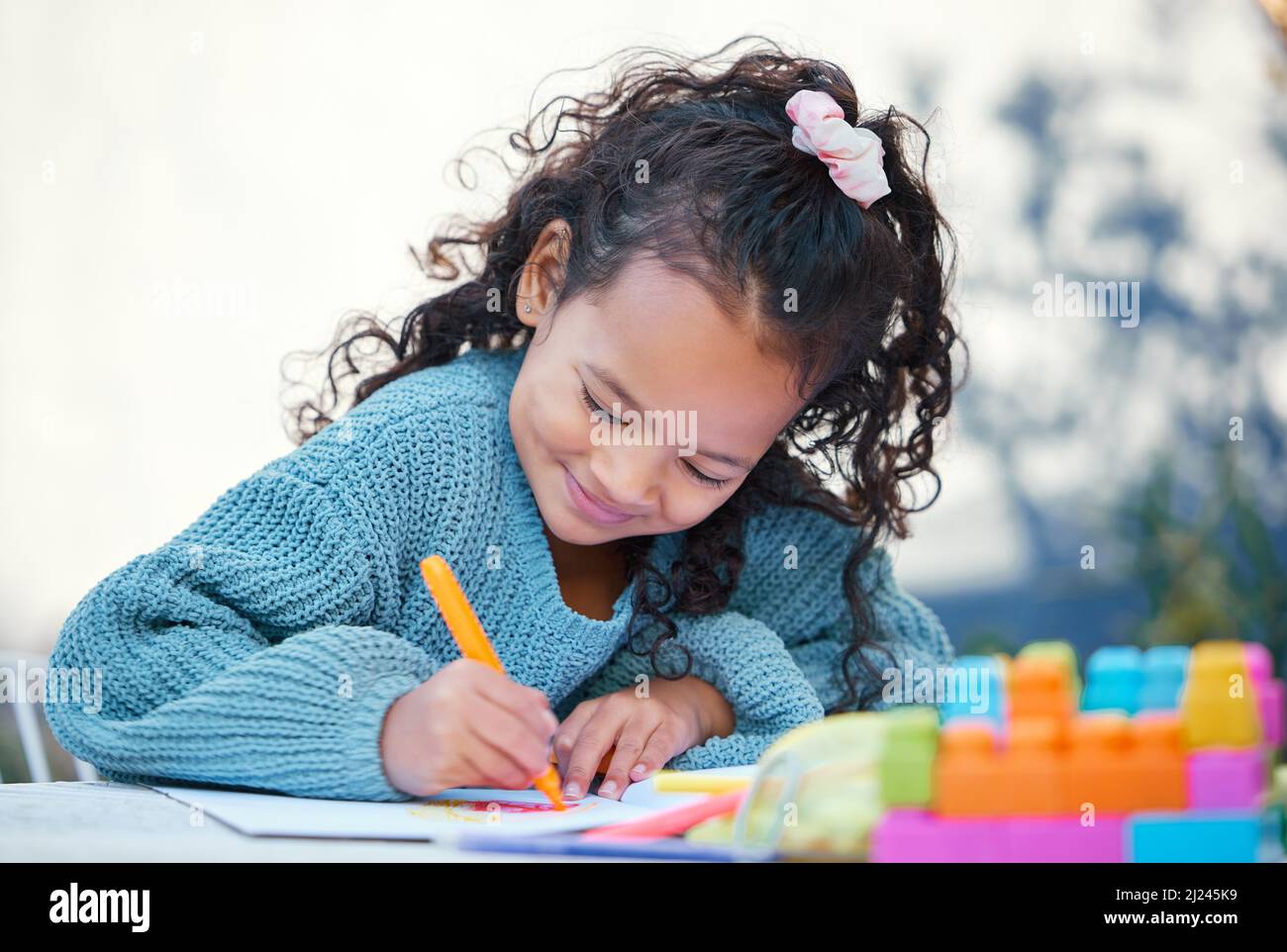Doing homework outside is so much better. Shot of a little girl ...