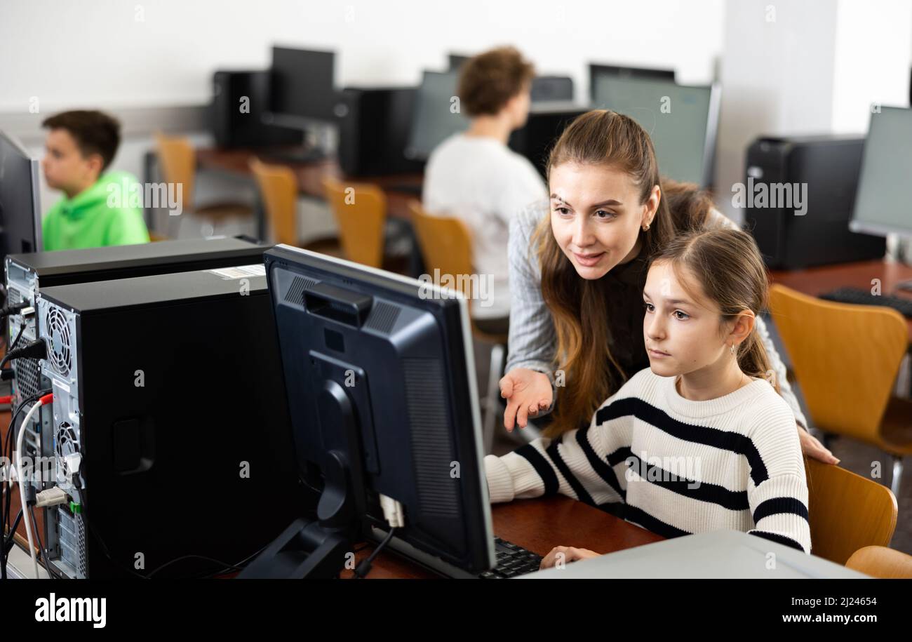 Teacher together with students conduct lesson on computer education ...